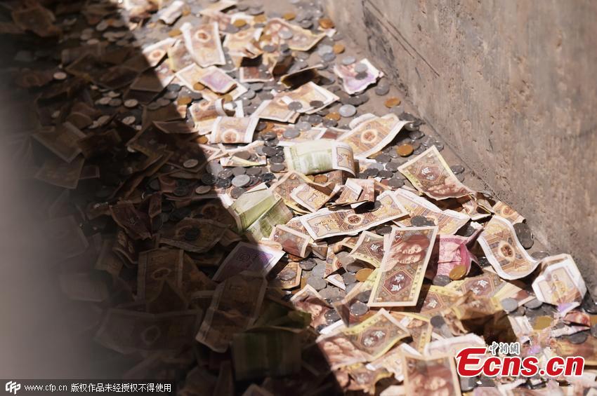 Visitors donate money into stone coffin for luck (1/3)